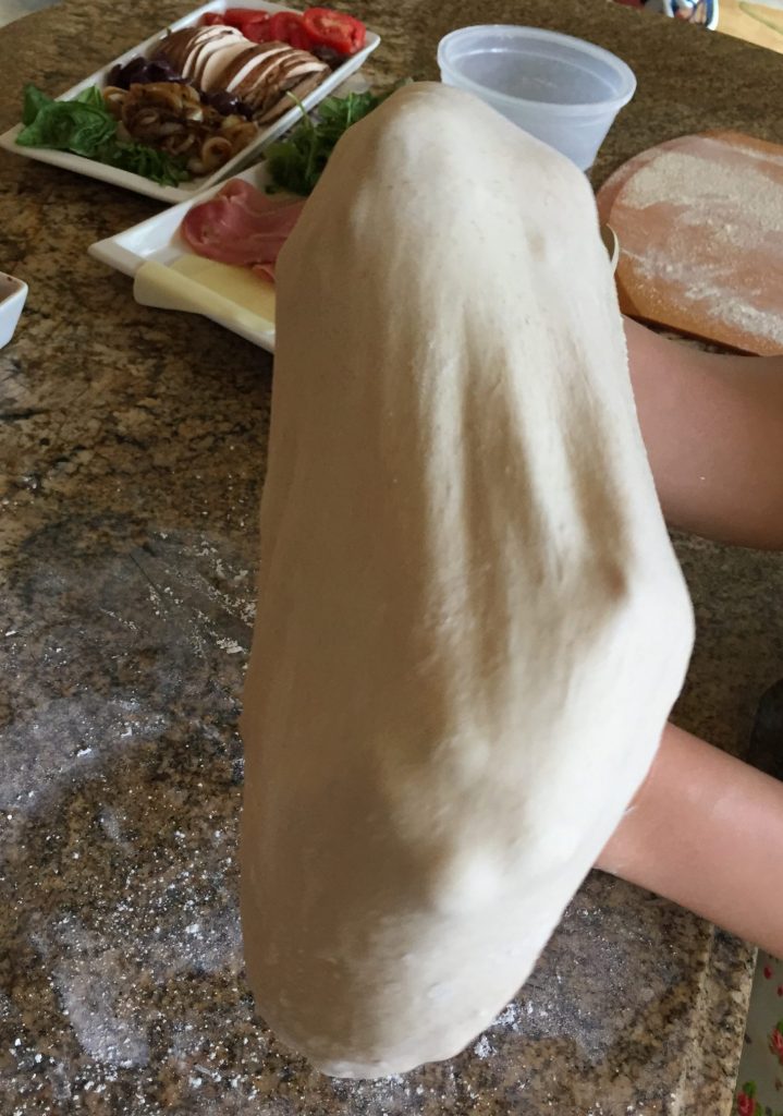 Stretching pizza dough and getting it into the oven - sammywongskitchen